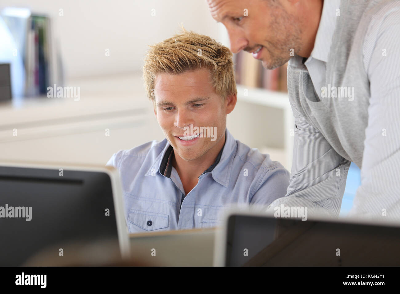 Manager with employee working in office Stock Photo - Alamy