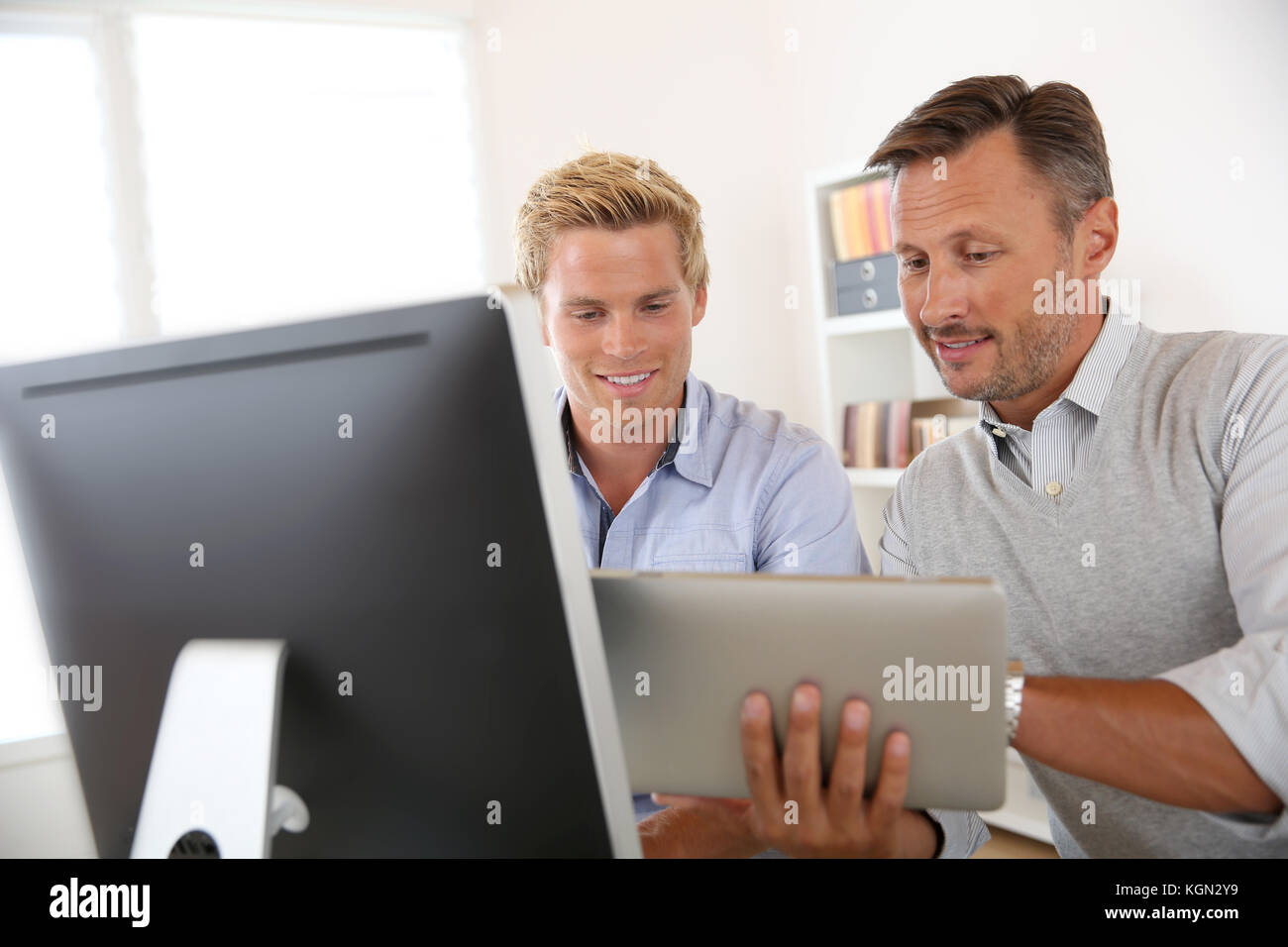 Manager with employee working in office Stock Photo - Alamy