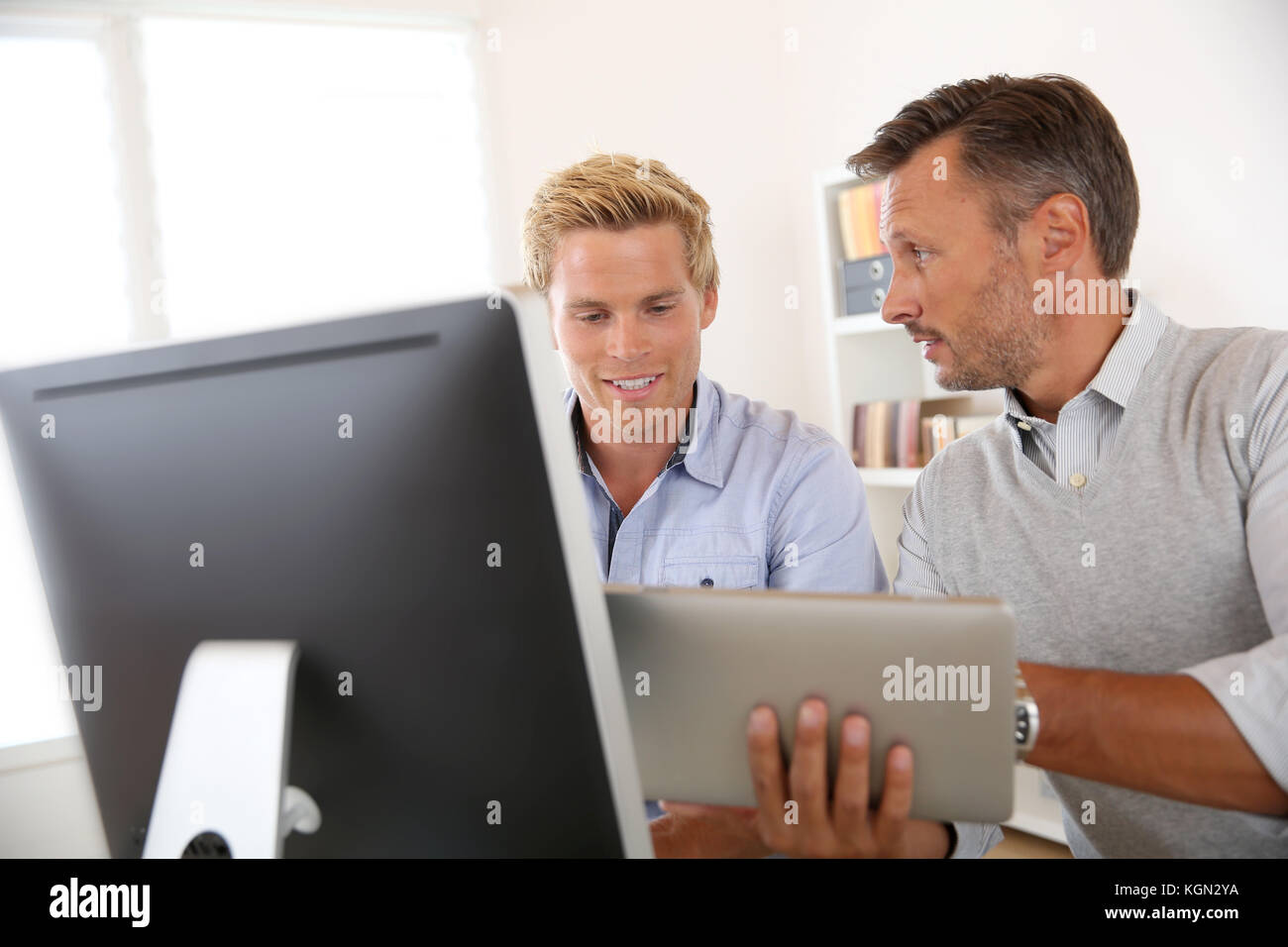Manager with employee working in office Stock Photo - Alamy