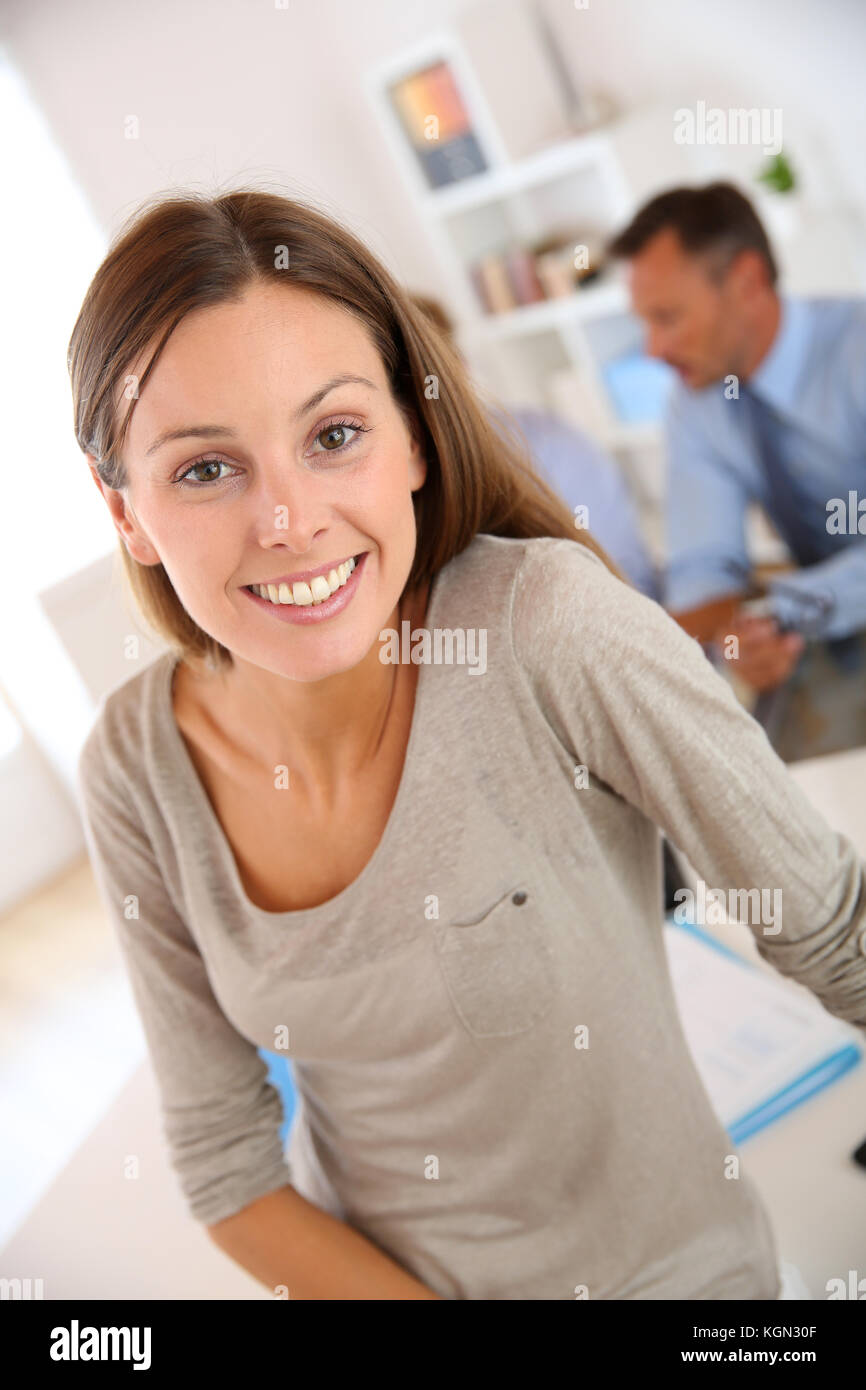 Smiling young woman in office Stock Photo - Alamy