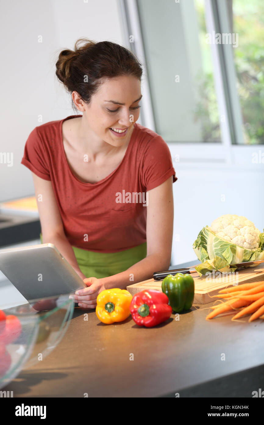 Woman in kitchen looking at recipe on tablet Stock Photo - Alamy