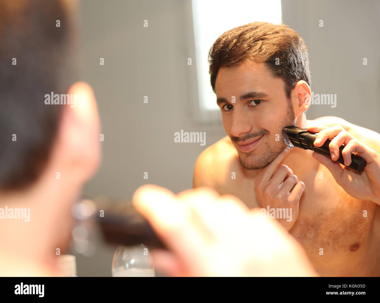 Man using electric shaver in bathroom Stock Photo - Alamy