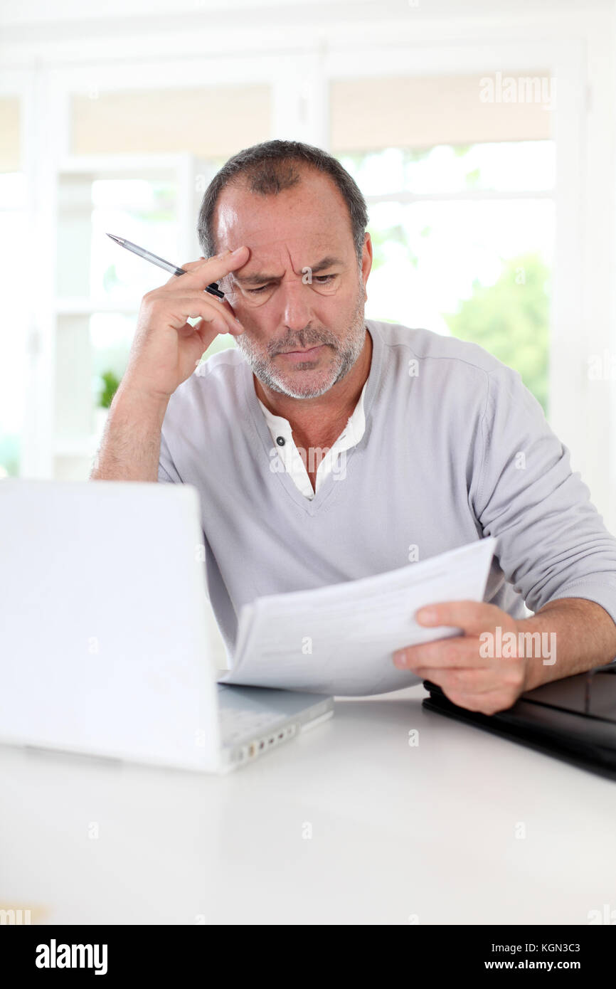 Senior man being puzzled with tax documents Stock Photo - Alamy