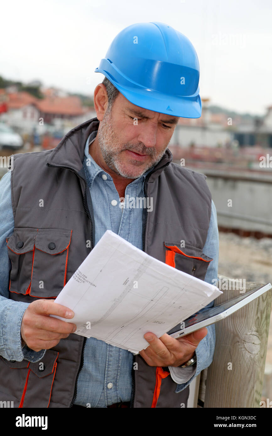 Construction manager controlling building site with plan Stock Photo ...