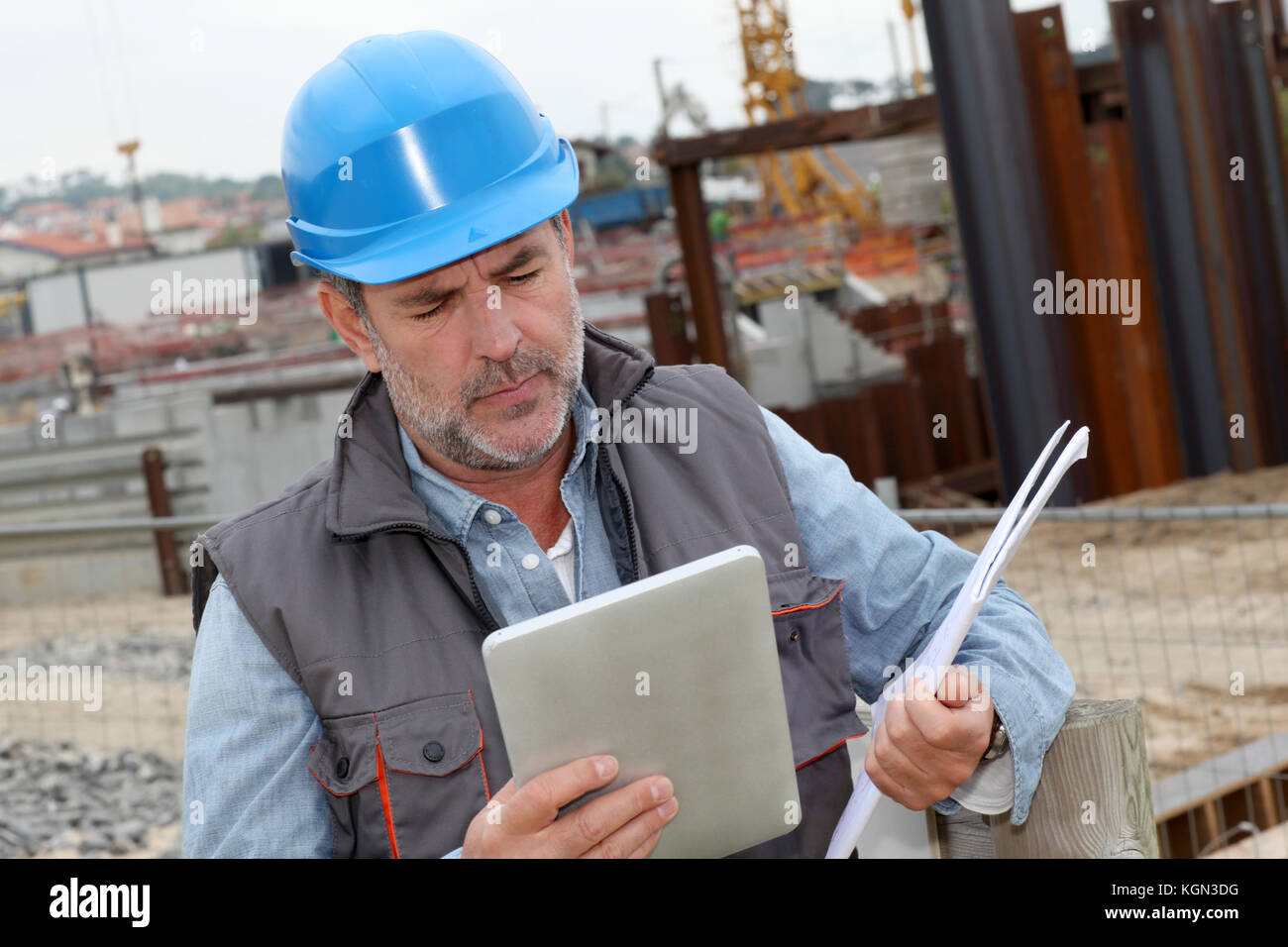 Construction manager controlling building site with plan Stock Photo ...