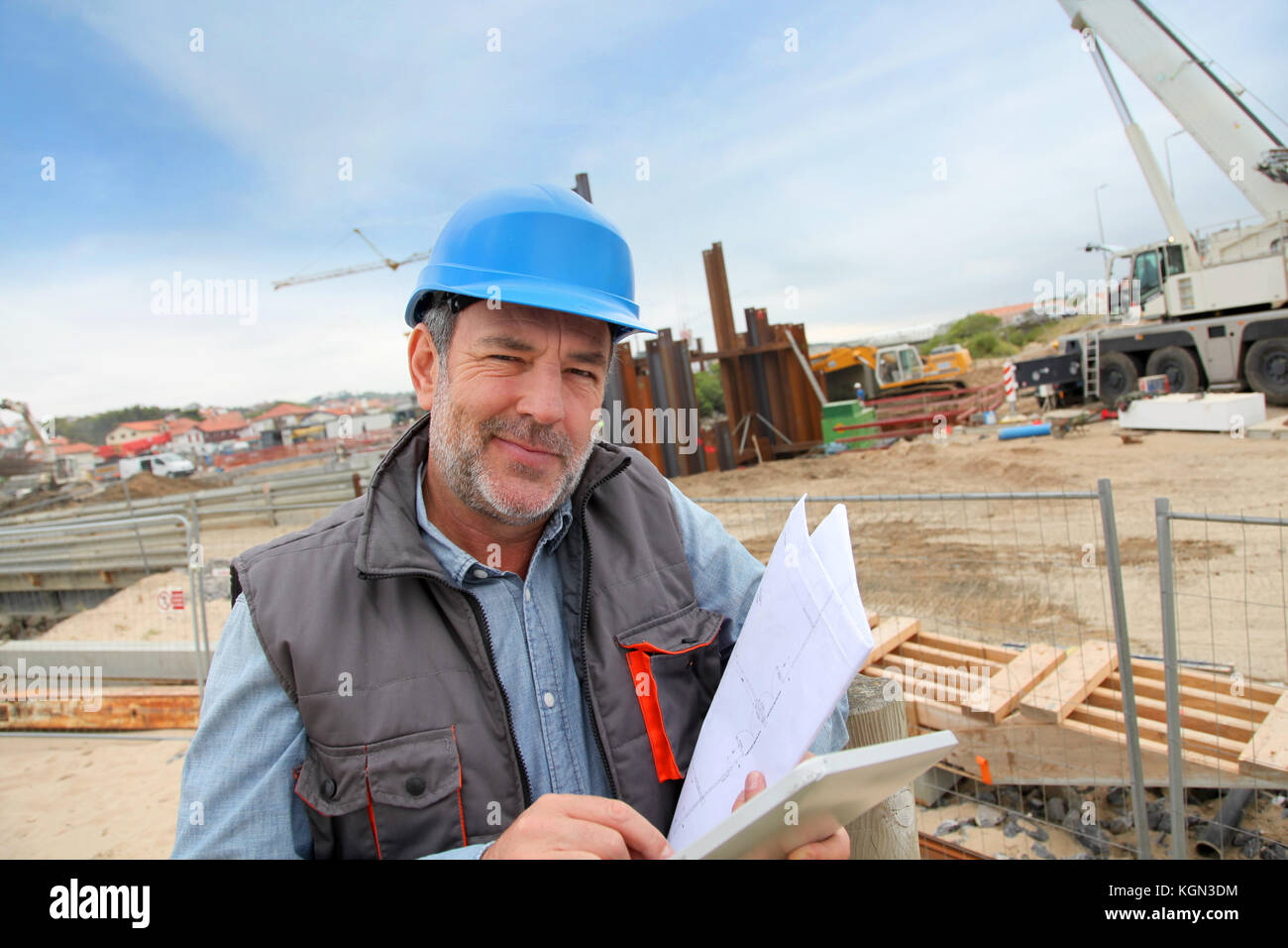 Construction manager controlling building site with plan Stock Photo ...