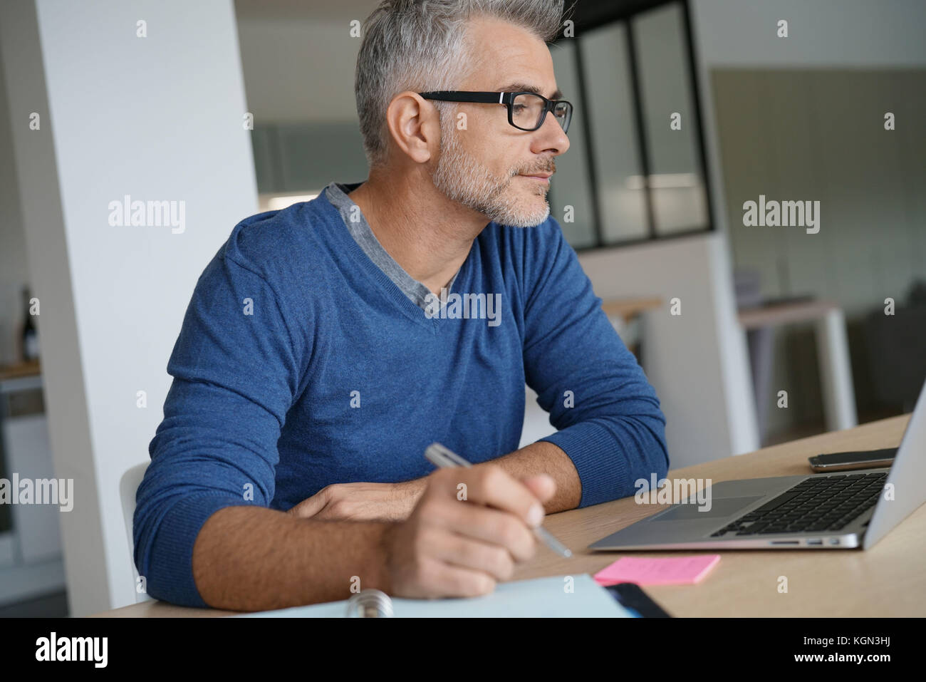 Middle-aged man working from home-office on laptop Stock Photo - Alamy