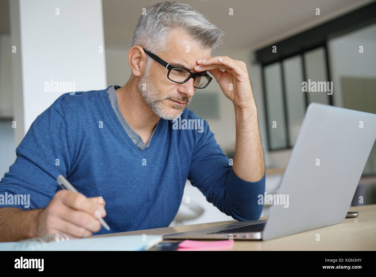 Middle-aged man working from home-office on laptop Stock Photo - Alamy