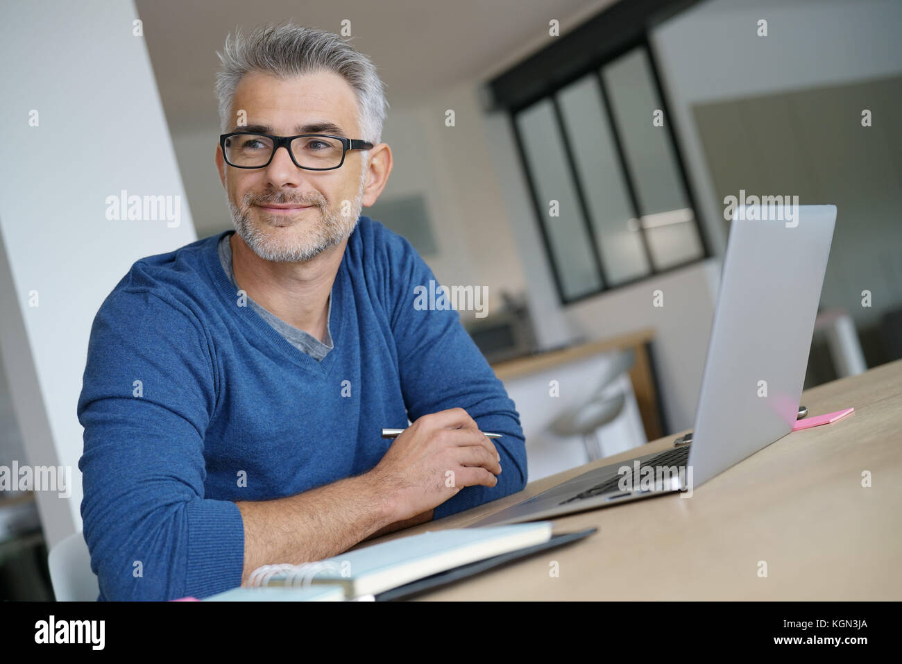 Middle-aged man working from home-office on laptop Stock Photo - Alamy