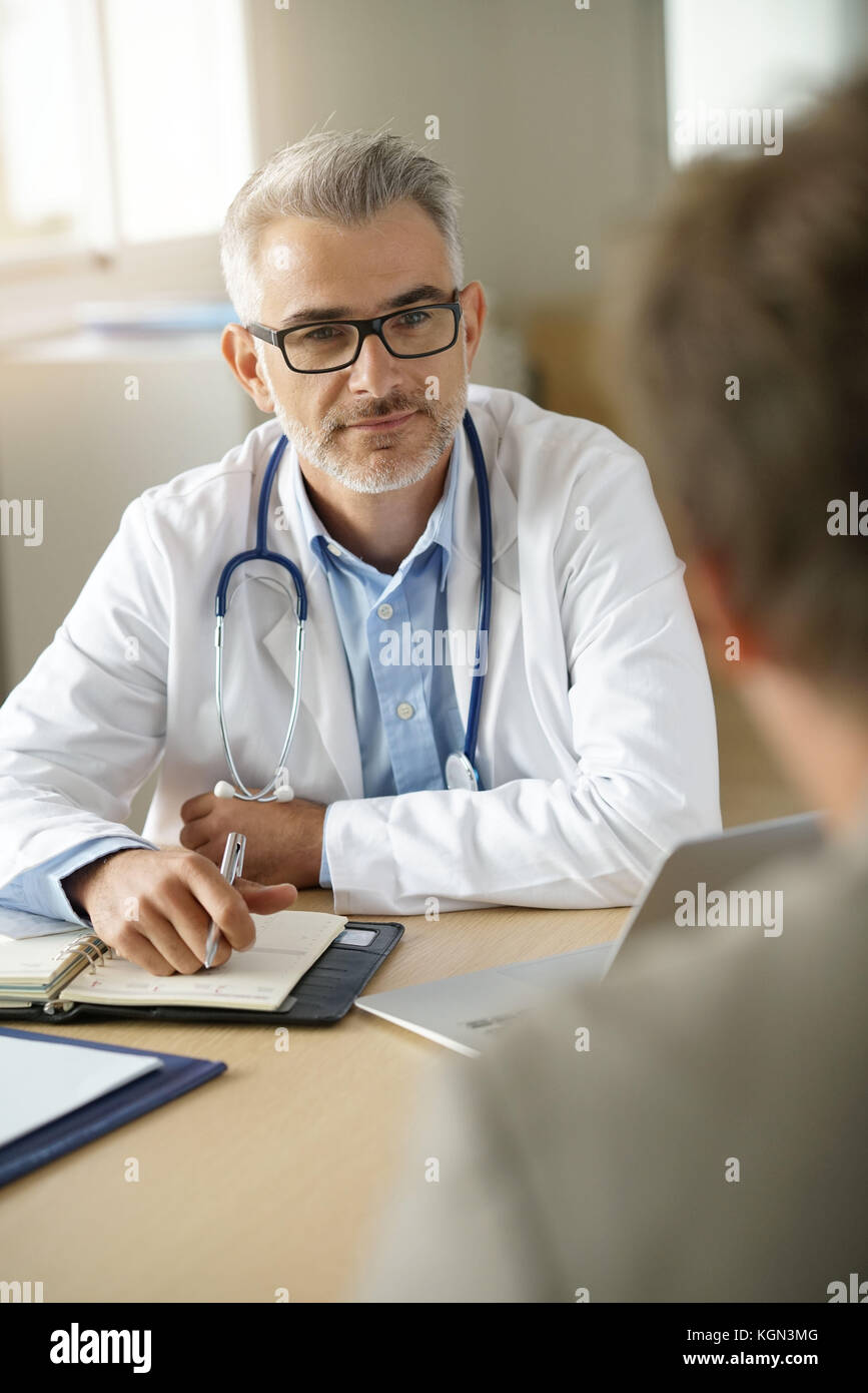 Doctor talking to patient in office Stock Photo - Alamy
