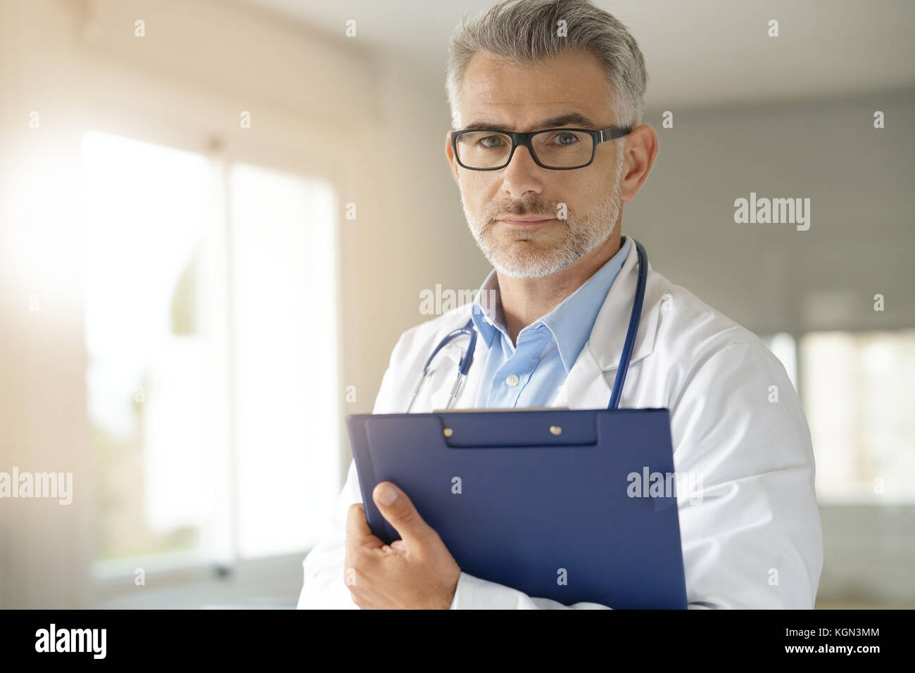 Portrait of doctor standing in office Stock Photo - Alamy