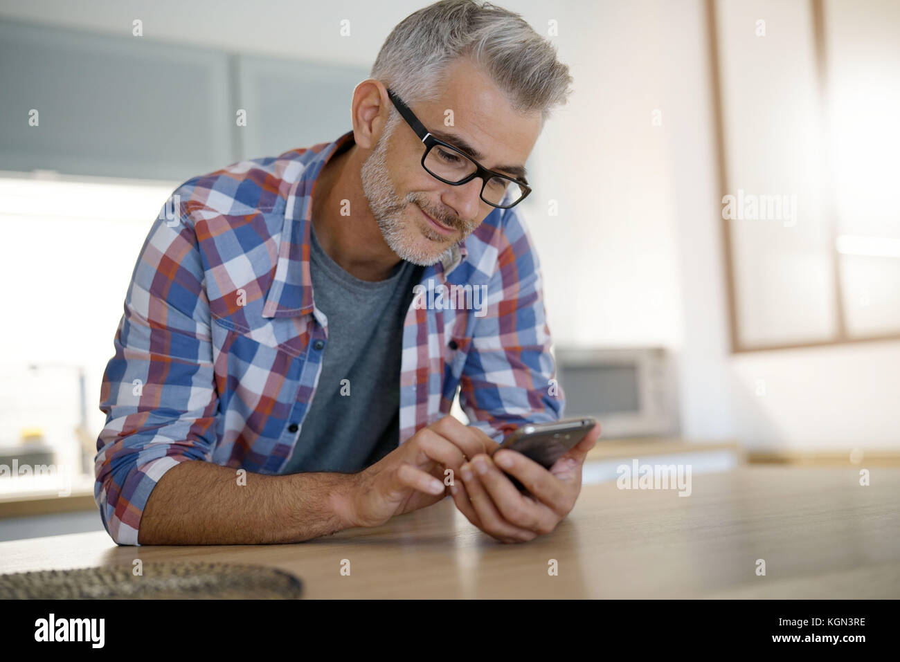 Middle-aged man at home using smartphone Stock Photo - Alamy