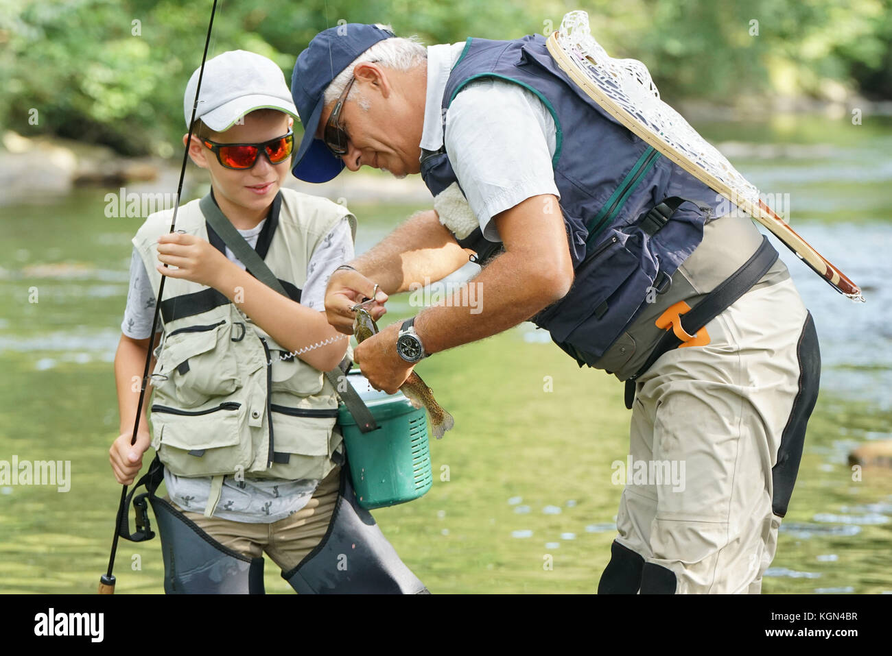 Father and son catching rainbow trout in river Stock Photo - Alamy