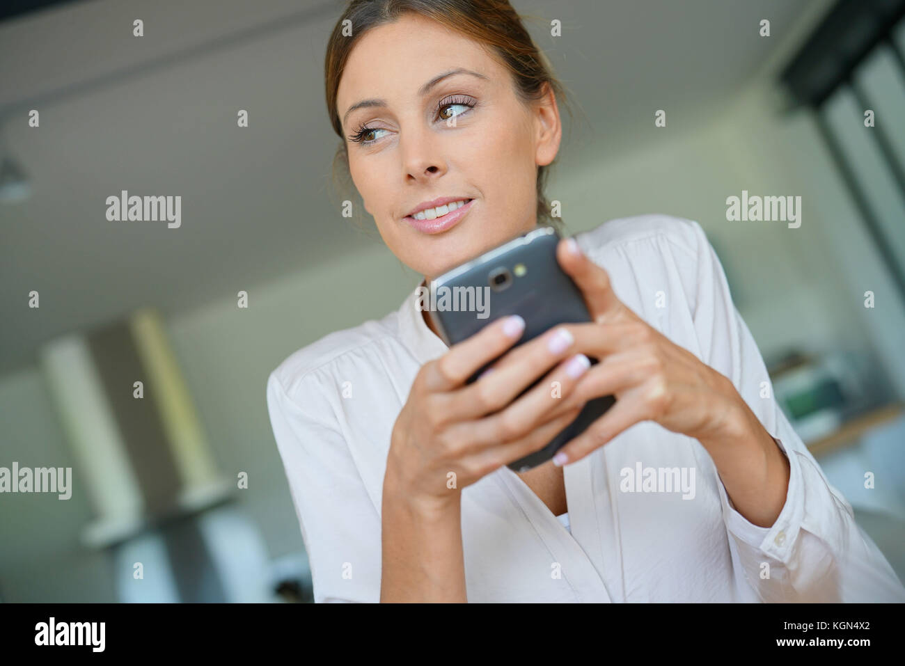 Cheerful woman sending message with smartphone Stock Photo - Alamy