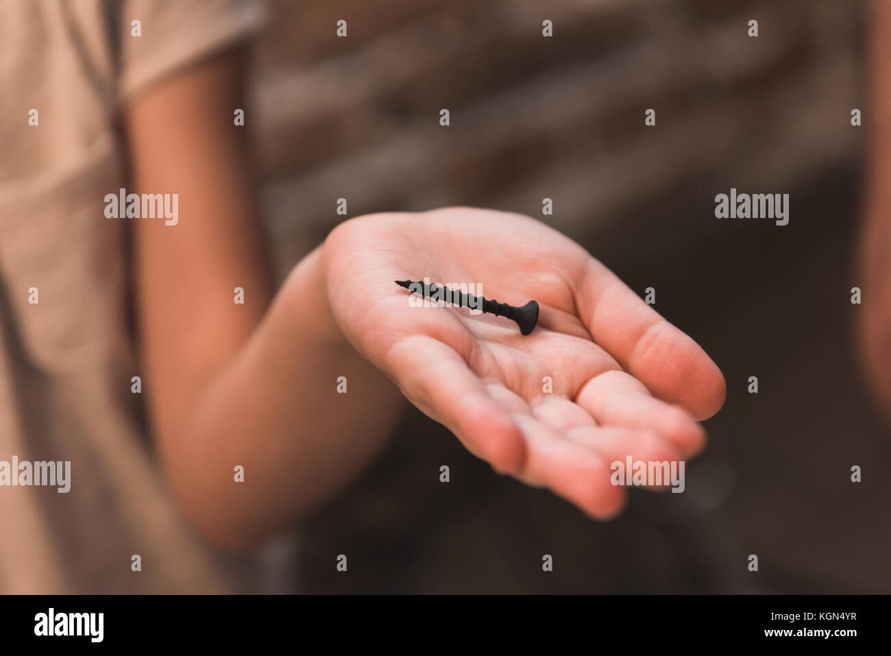 Child holding screw in hand Stock Photo - Alamy