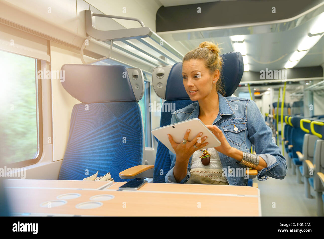 Smiling young woman in train connected on tablet Stock Photo - Alamy