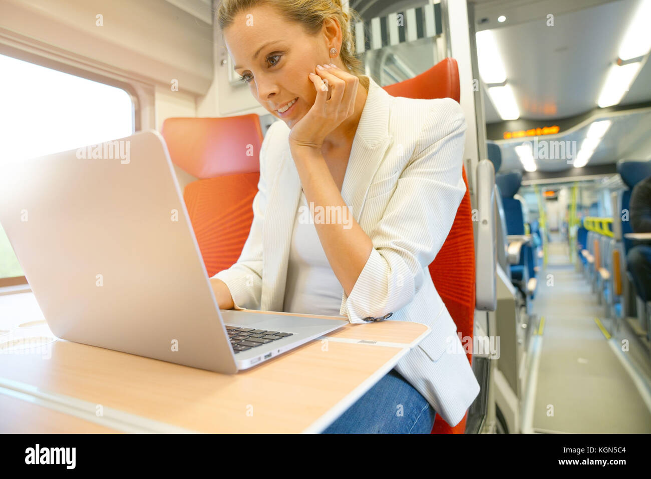 Businesswoman in train connected on laptop computer Stock Photo - Alamy
