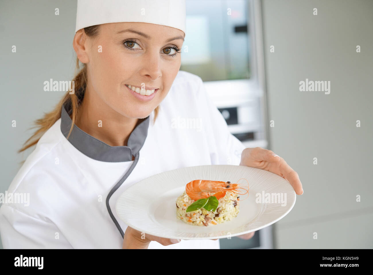 Cook chef presenting dish to camera Stock Photo - Alamy