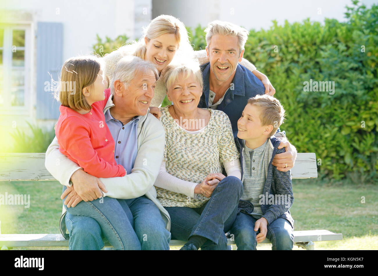 Portrait of intergenerational family sitting on bench Stock Photo - Alamy