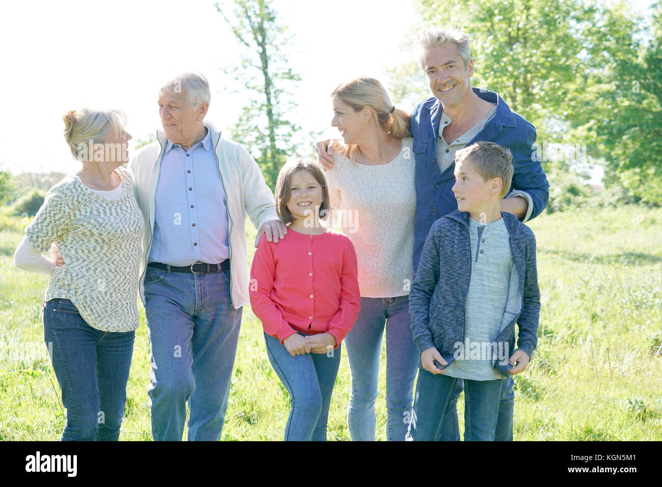 Intergenerational family walking together in park Stock Photo - Alamy