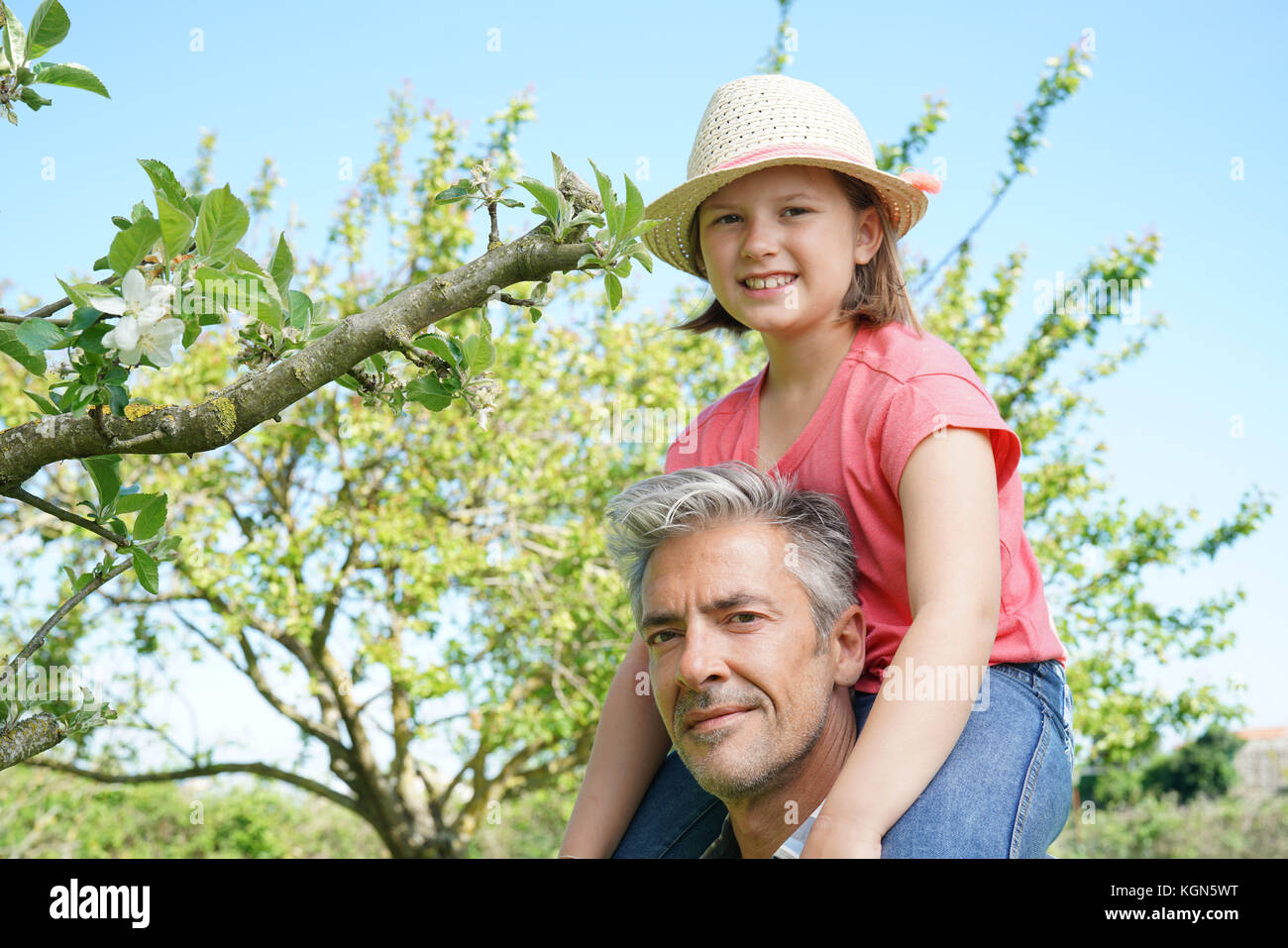 Man with young girl looking at fruit trees buds Stock Photo - Alamy