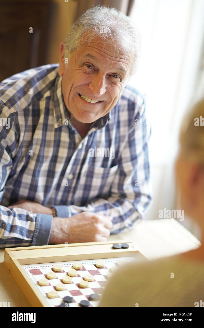 Senior couple playing checkers together Stock Photo - Alamy