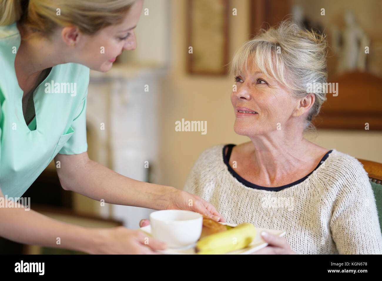 Nurse bringing breakfast to senior female patient Stock Photo - Alamy