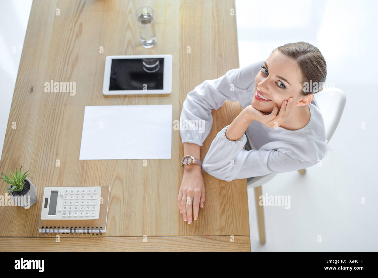 Smiling businesswoman at desk in office Stock Photo - Alamy