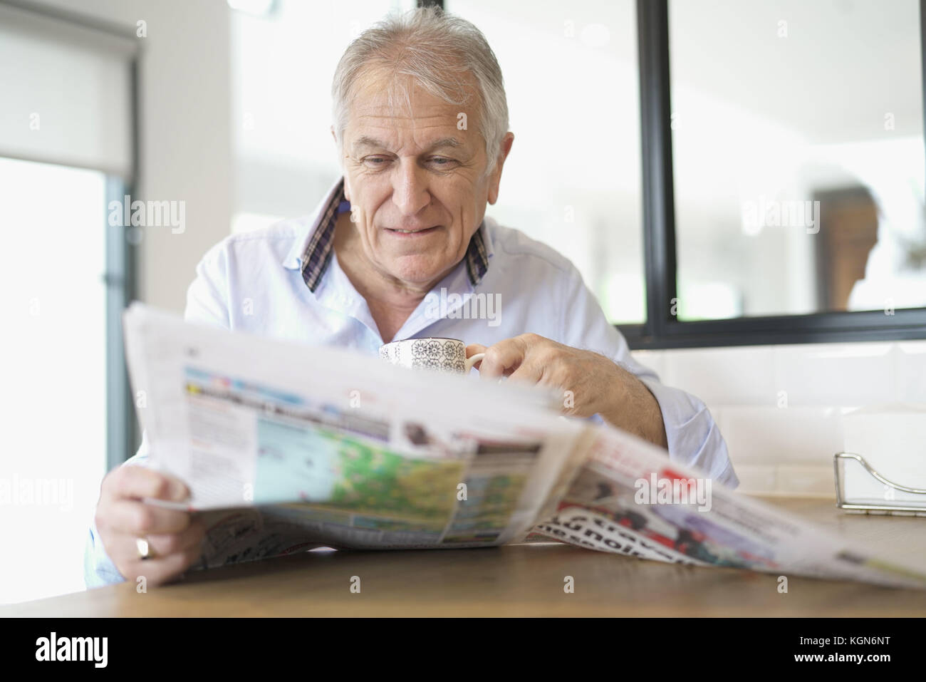 Senior man at home reading newspaper Stock Photo - Alamy