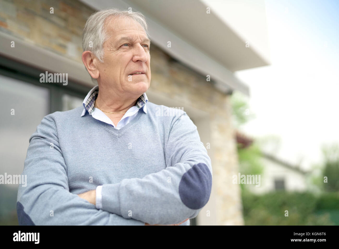Senior man standing outside house Stock Photo - Alamy