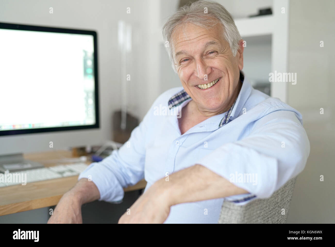 Senior man at home sitting in front of desktop computer Stock Photo - Alamy