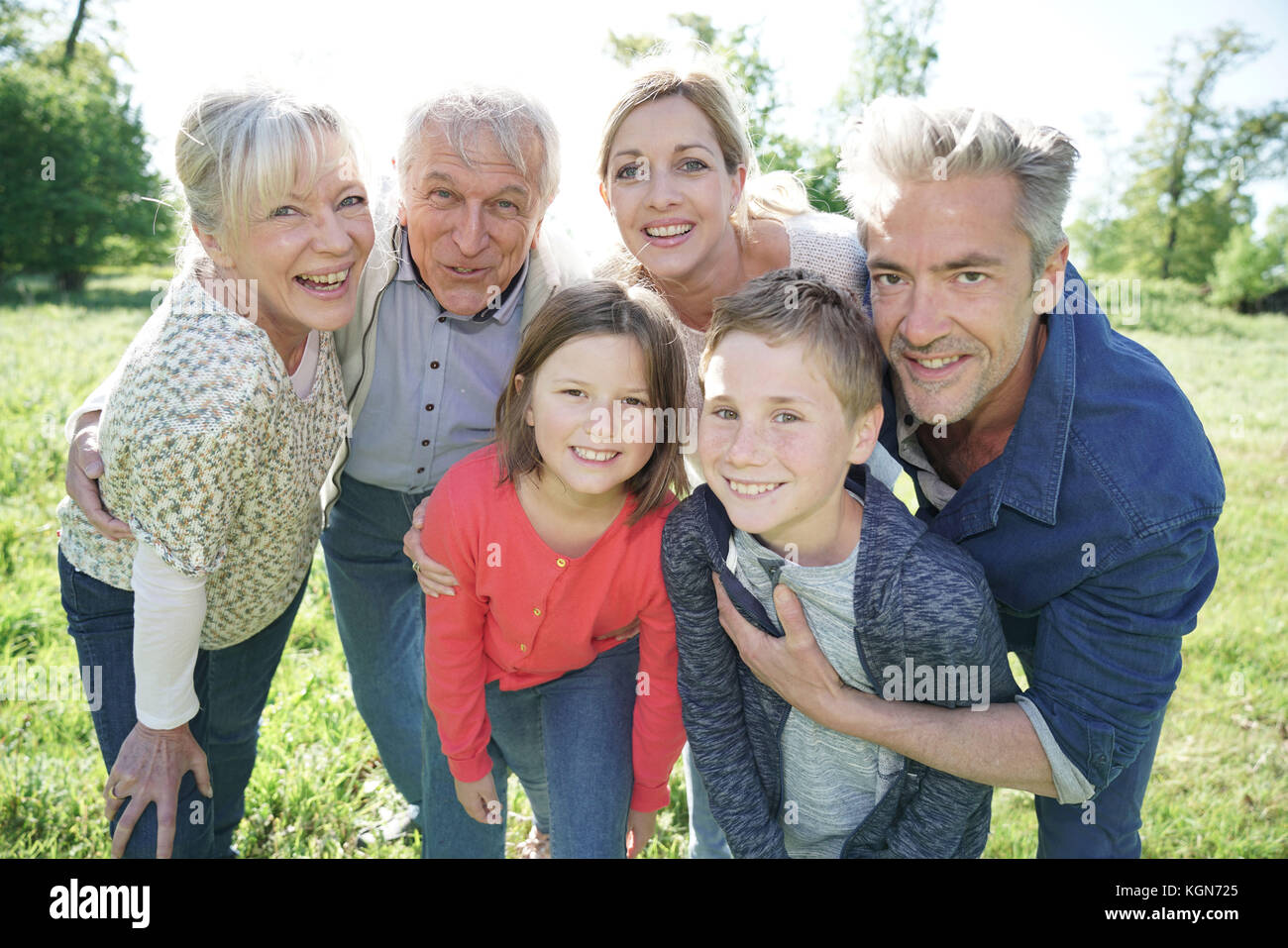 Happy intergenerational family walking in park Stock Photo - Alamy