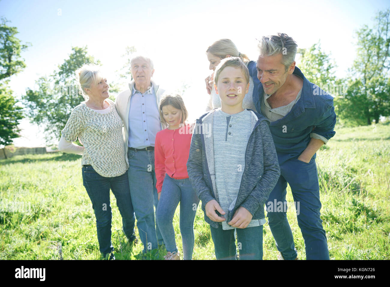 Happy intergenerational family walking in park Stock Photo - Alamy