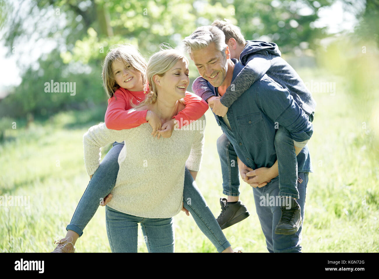 Couple giving piggyback ride children hi-res stock photography and ...