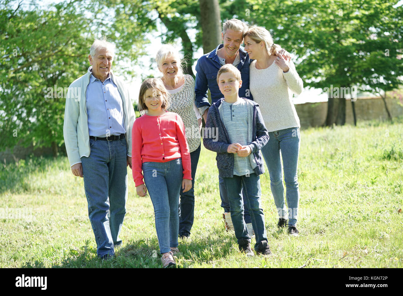 Happy intergenerational family walking in garden Stock Photo - Alamy