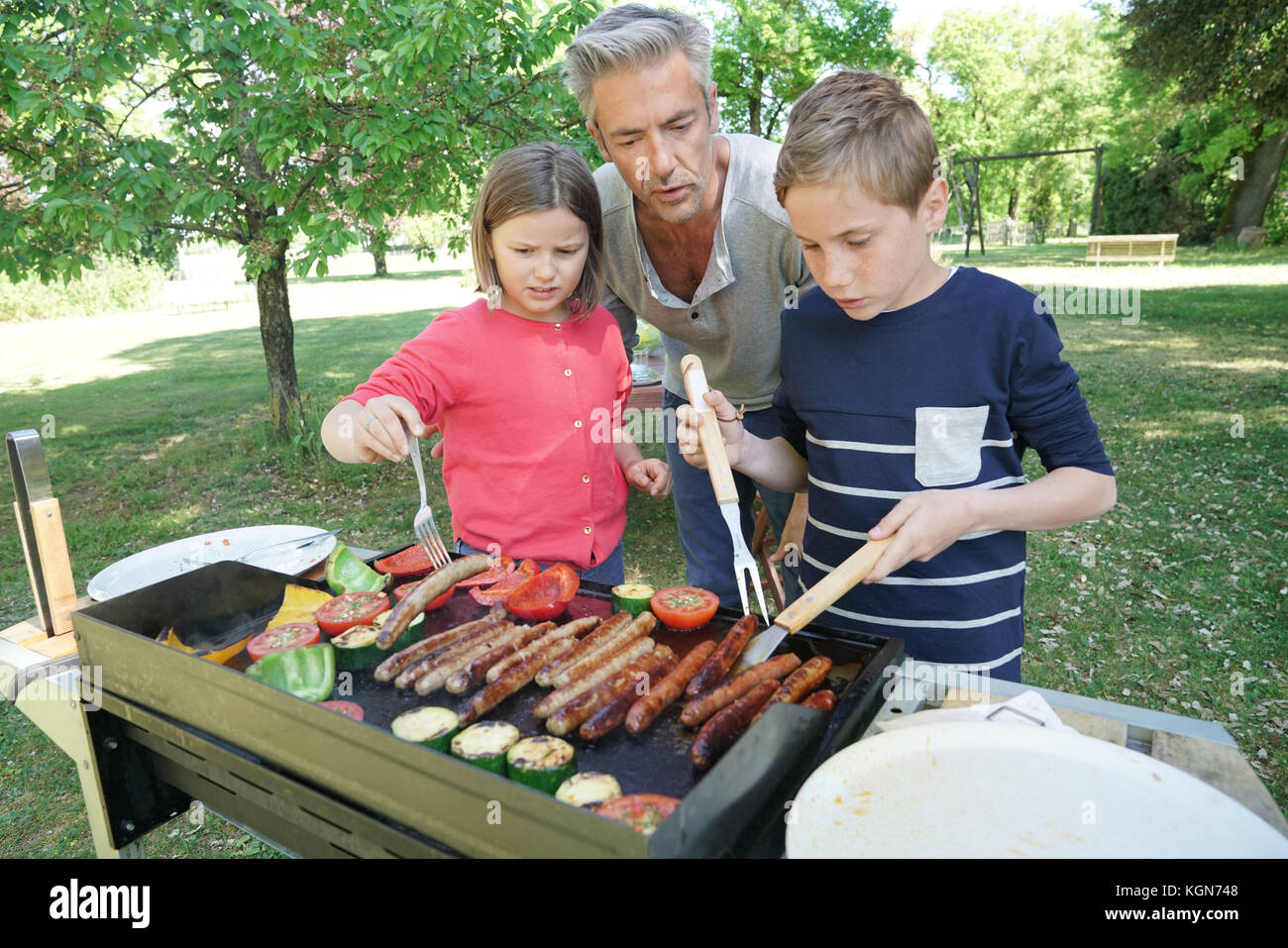 Father with kids preparing barbecue for family lunch Stock Photo - Alamy