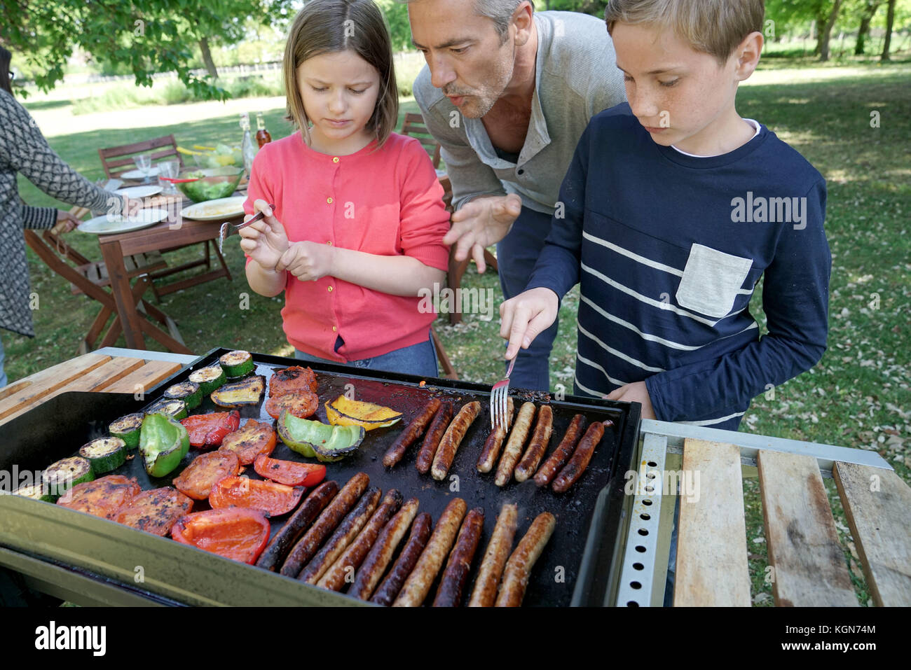 Father with kids preparing barbecue for family lunch Stock Photo - Alamy