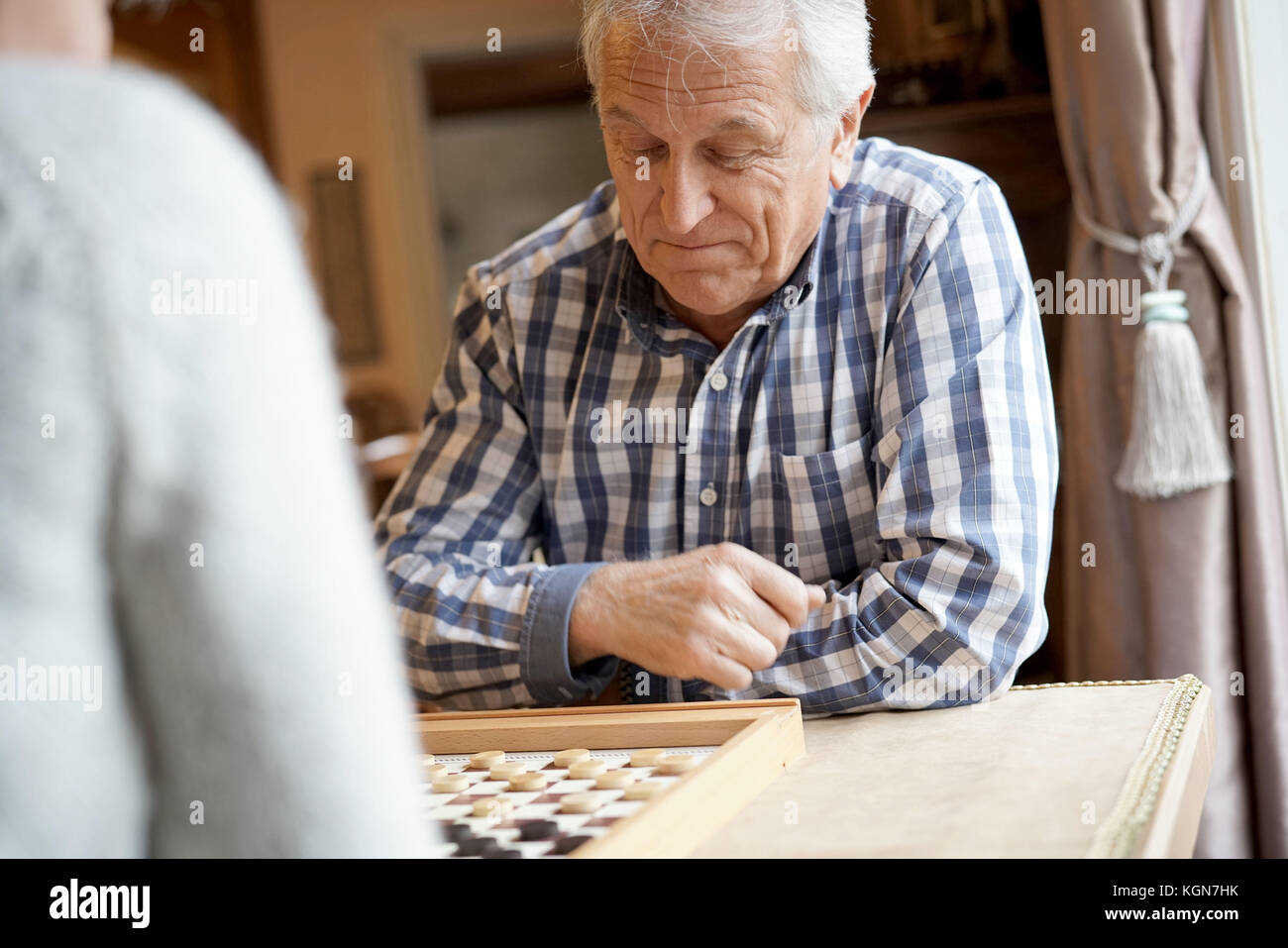 Senior couple playing checkers together Stock Photo - Alamy