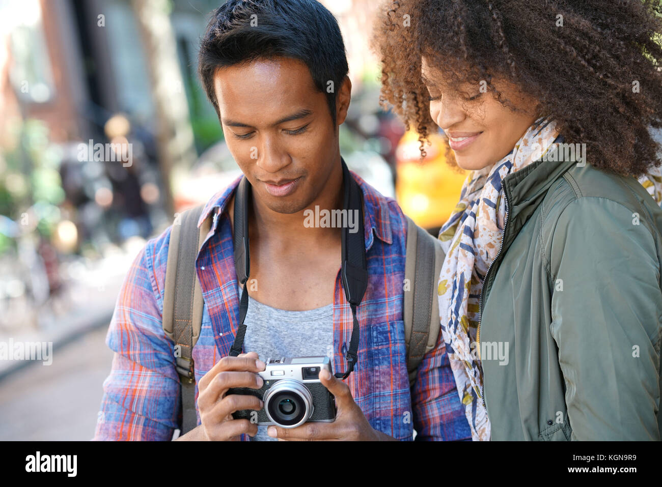 Man showing pictures to girlfriend on camera screen Stock Photo - Alamy