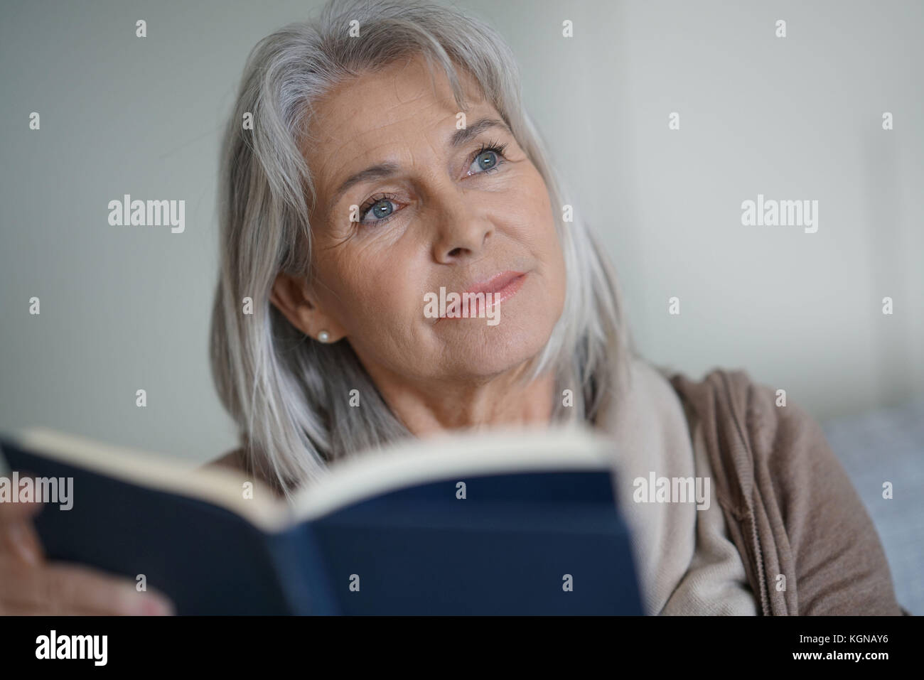 Senior woman reading book at home Stock Photo - Alamy