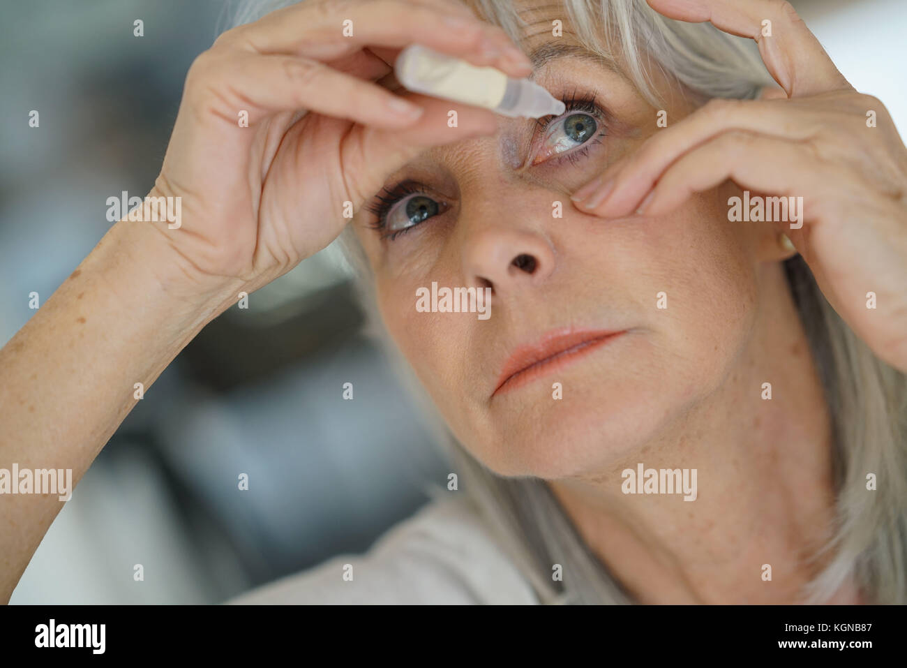 Senior woman putting eye drop Stock Photo - Alamy