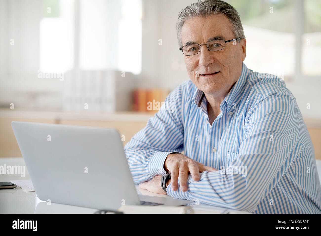 Senior man in office working on laptop computer Stock Photo - Alamy