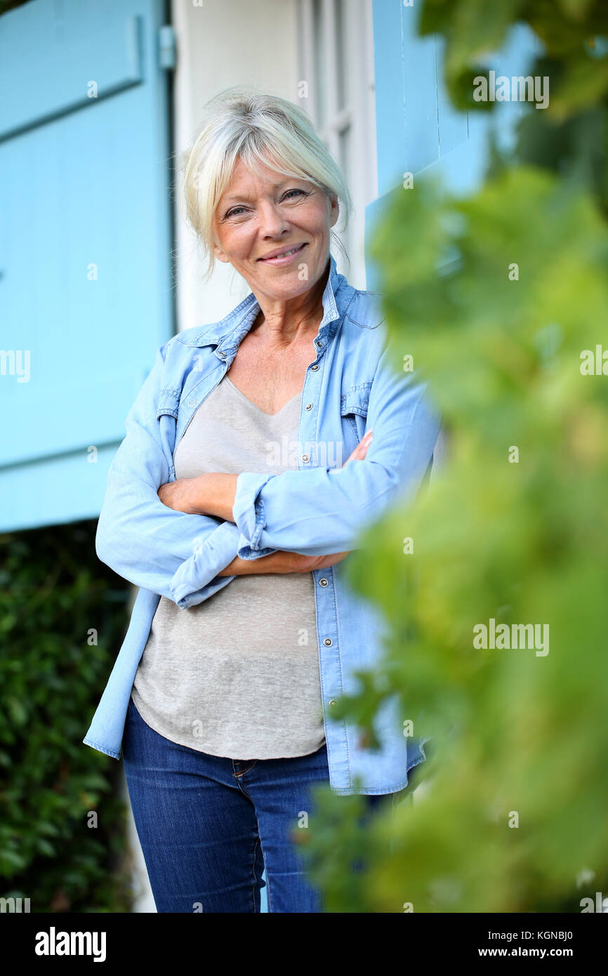 Senior woman standing outside the house Stock Photo - Alamy