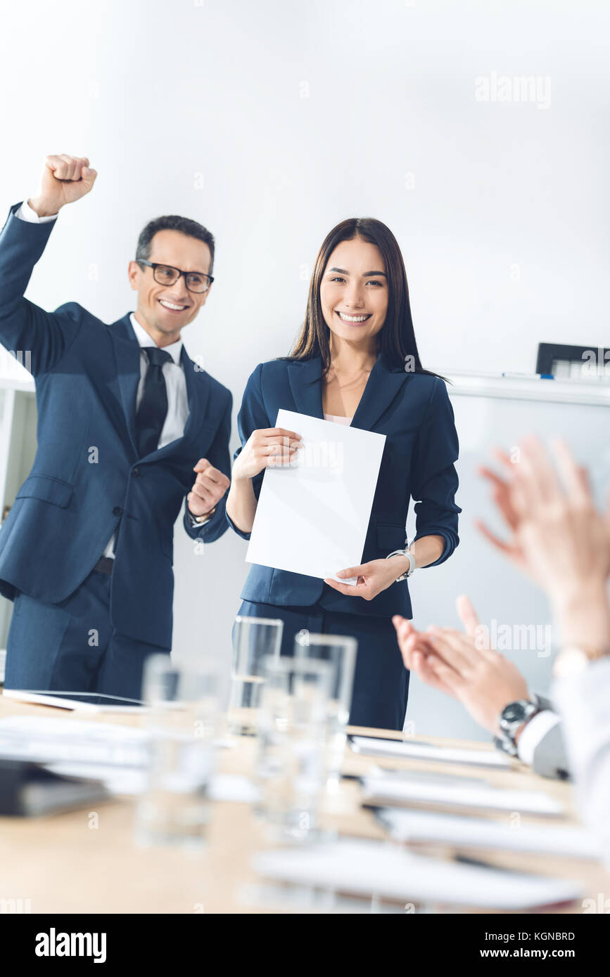 rewarded manageress holding blank paper Stock Photo - Alamy