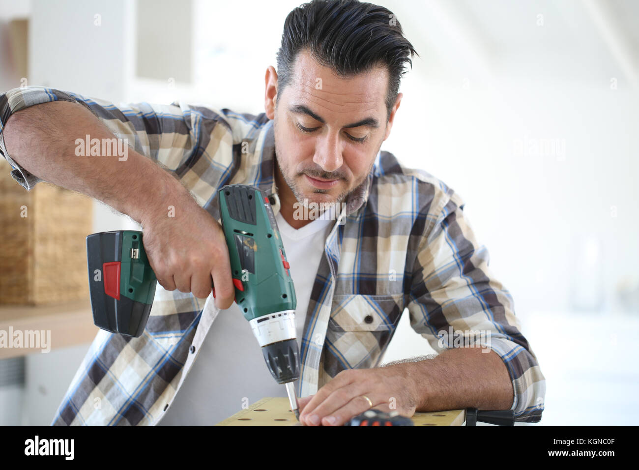 Man at home using electric drill Stock Photo - Alamy