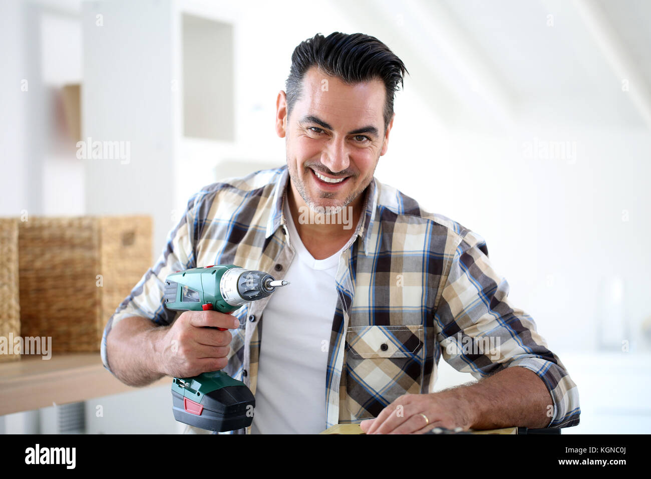 Man at home using electric drill Stock Photo - Alamy