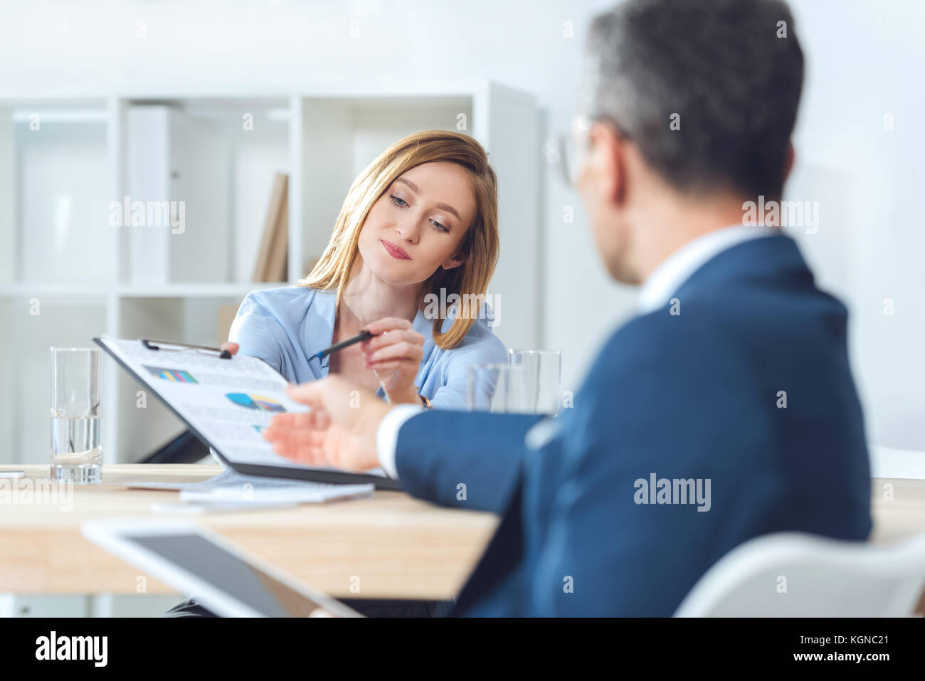 businesswoman giving documents to partner Stock Photo - Alamy