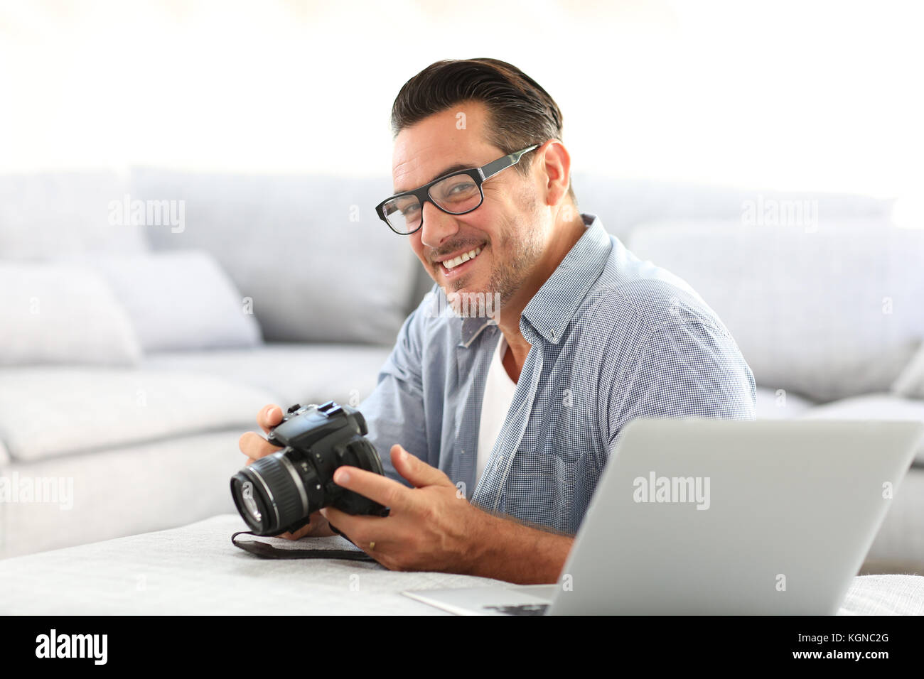 Man at home using reflex camera and laptop Stock Photo - Alamy