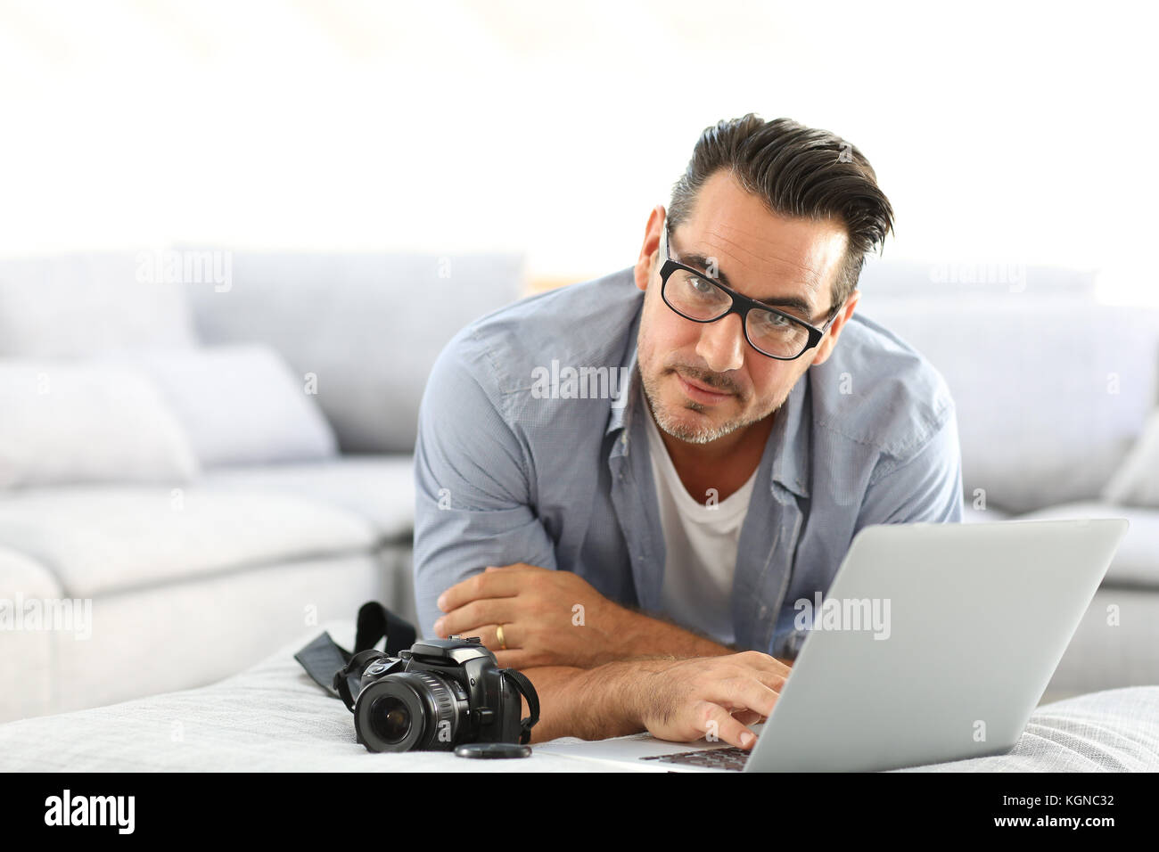 Man at home using reflex camera and laptop Stock Photo - Alamy