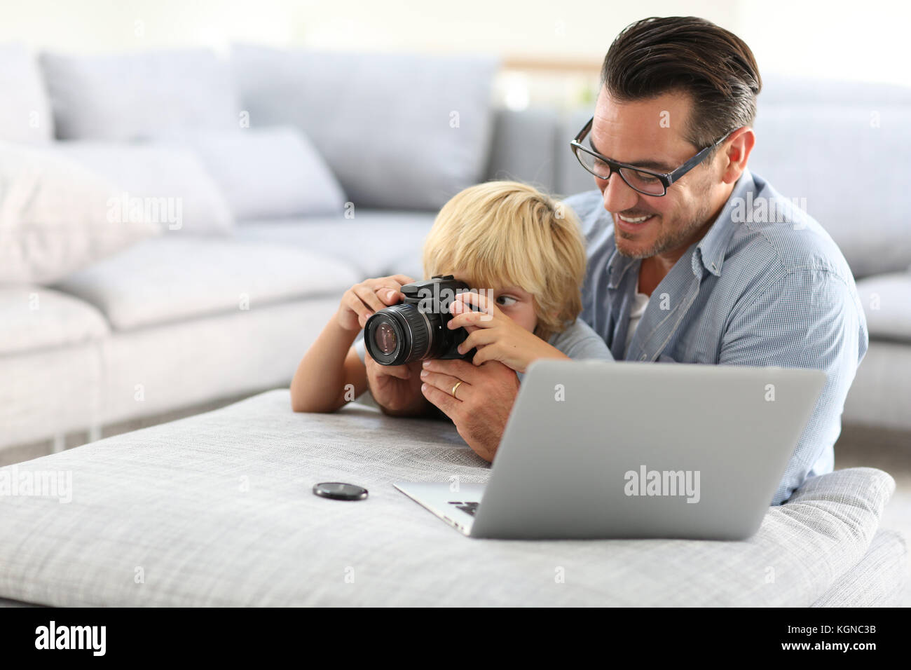 Man with little boy playing with reflex camera Stock Photo - Alamy